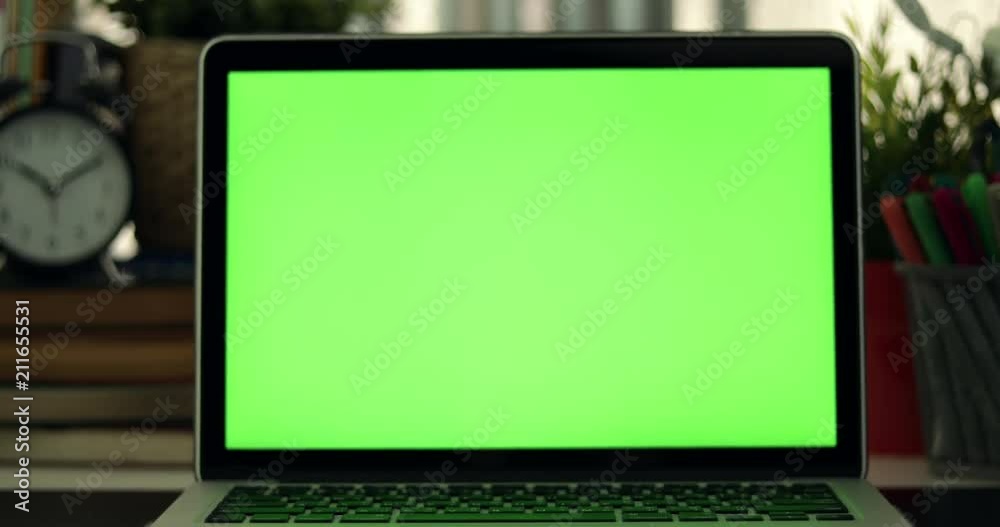 Dolly in of Laptop with green screen. Dark office. Perfect to put your ...