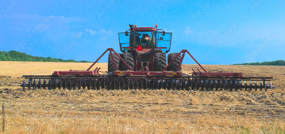 red tractor for harvesting in the midst of the summer season, produces ...