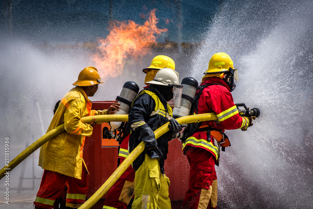 Fireman using water and extinguisher to fighting with fire flame in an ...