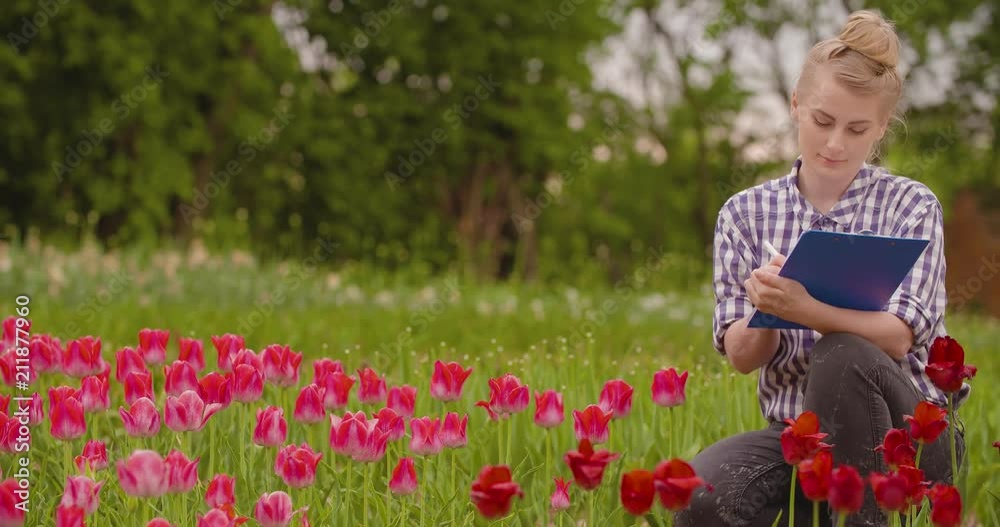 Female Researcher Walking While Examining Tulips At Field Stock Video ...