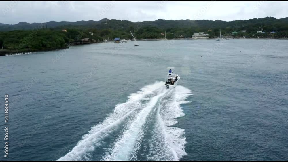 This is a drone shot following a dive boat in the caribbean ocean. This ...