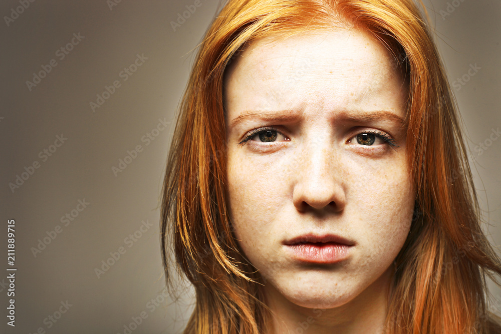 Beautiful fragile redheaded young woman in the dark. Sad frightened ...