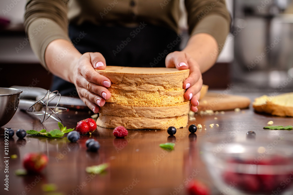 The pastry chef prepares a biscuit cake in the home kitchen or in a ...