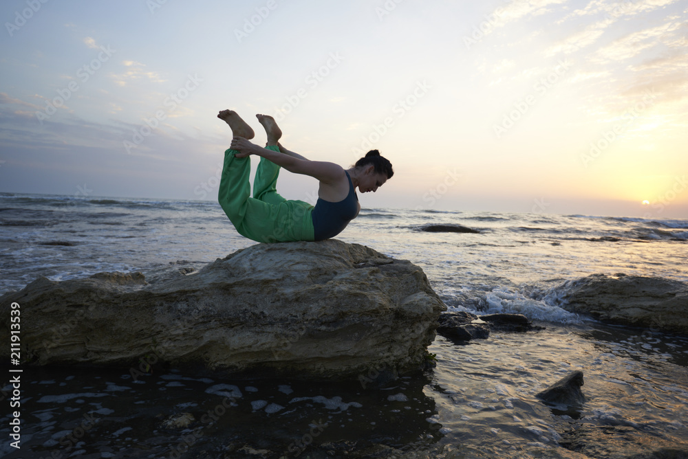 Woman silhouette on sunset sky background young active girl sit in yoga ...