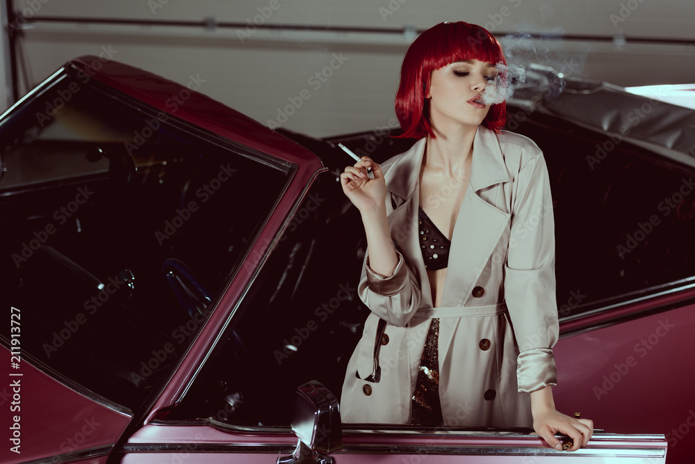 stylish girl in red wig and trench coat smoking cigarette in classic ...