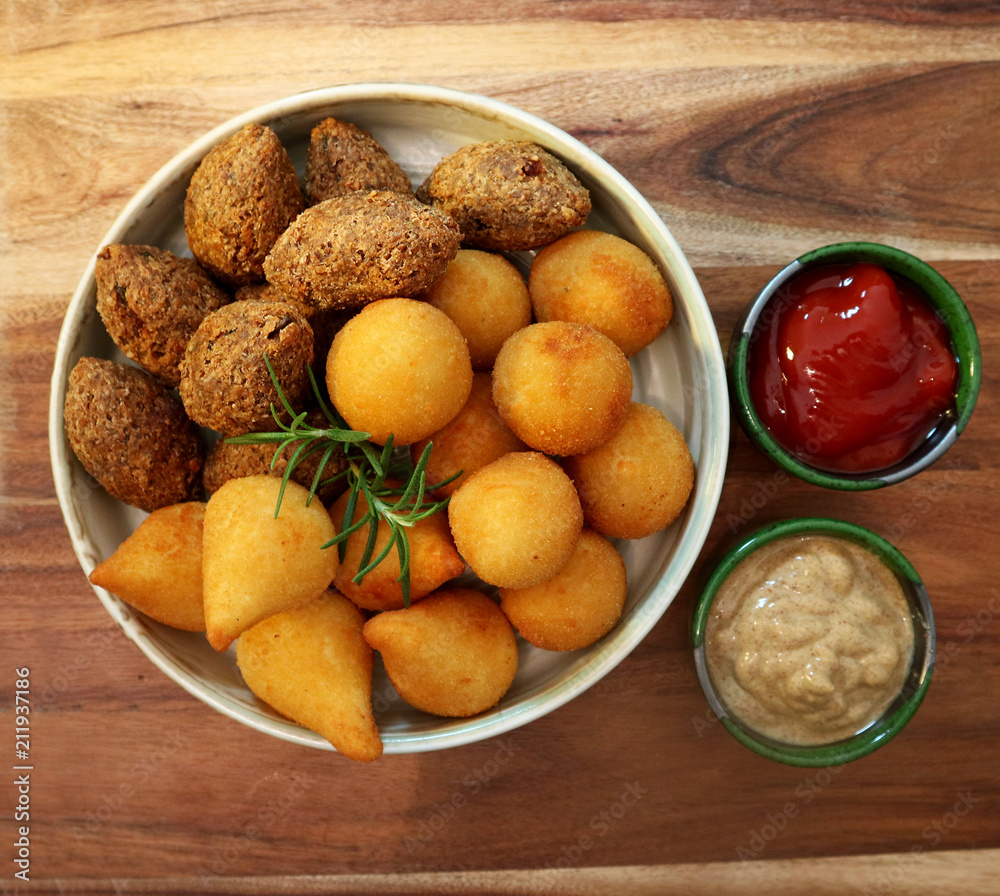 Traditional Brazilian snacks coxinha and quibe on wooden background ...
