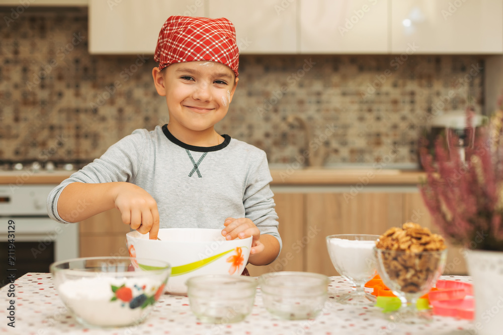 Cute boy cooking in kitchen at home looking to camera Stock Photo ...