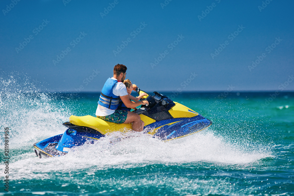 happy, excited family, father and son having fun on jet ski at summer ...