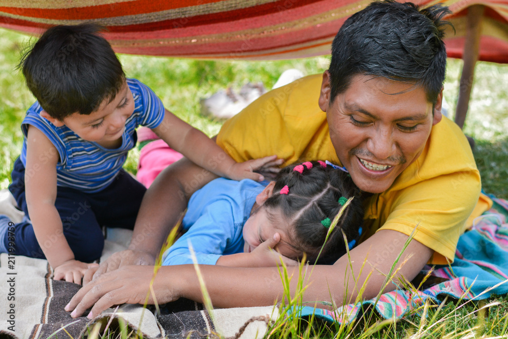 Latin dad with his two little children having good time in the hovel ...