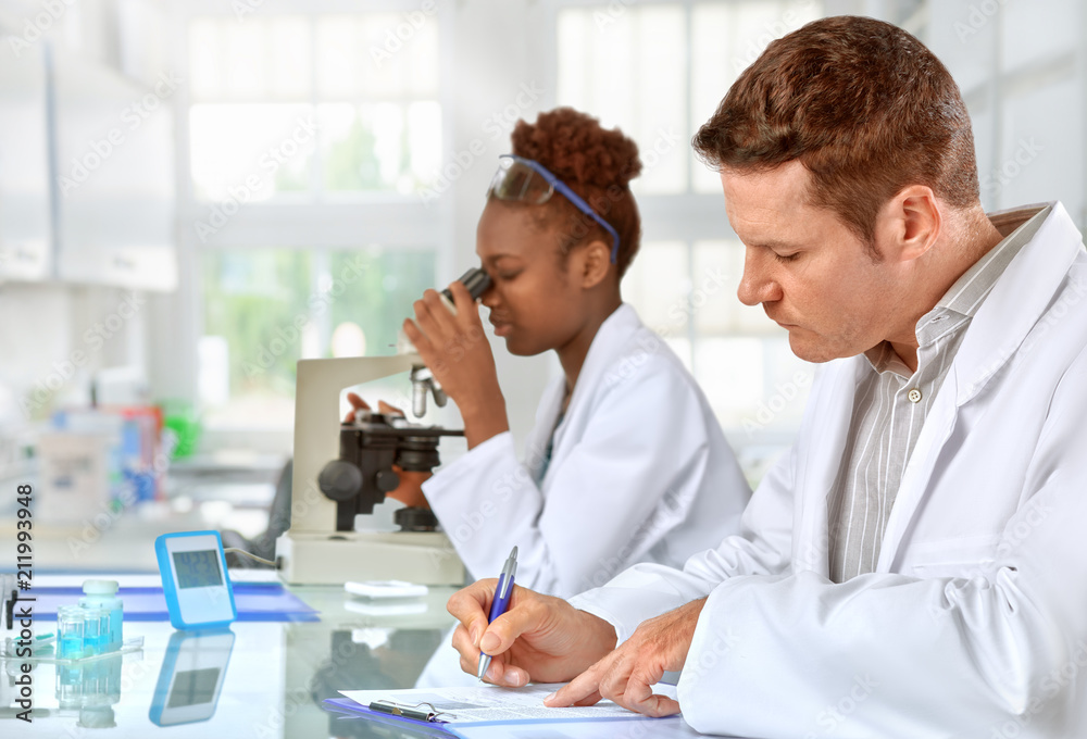 Scientists, male and female, work in research facility Stock Photo ...