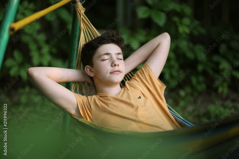 teenager boy resting sleep in hammock on summer green garden background ...