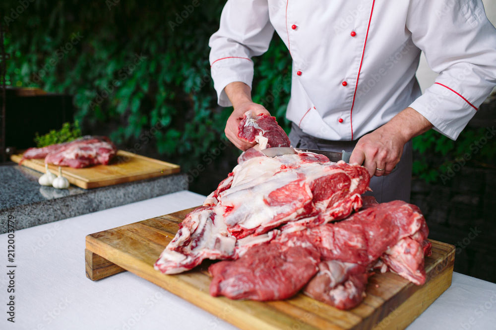 A man cook cuts meat with a knife in a restaurant. Stock Photo | Adobe ...