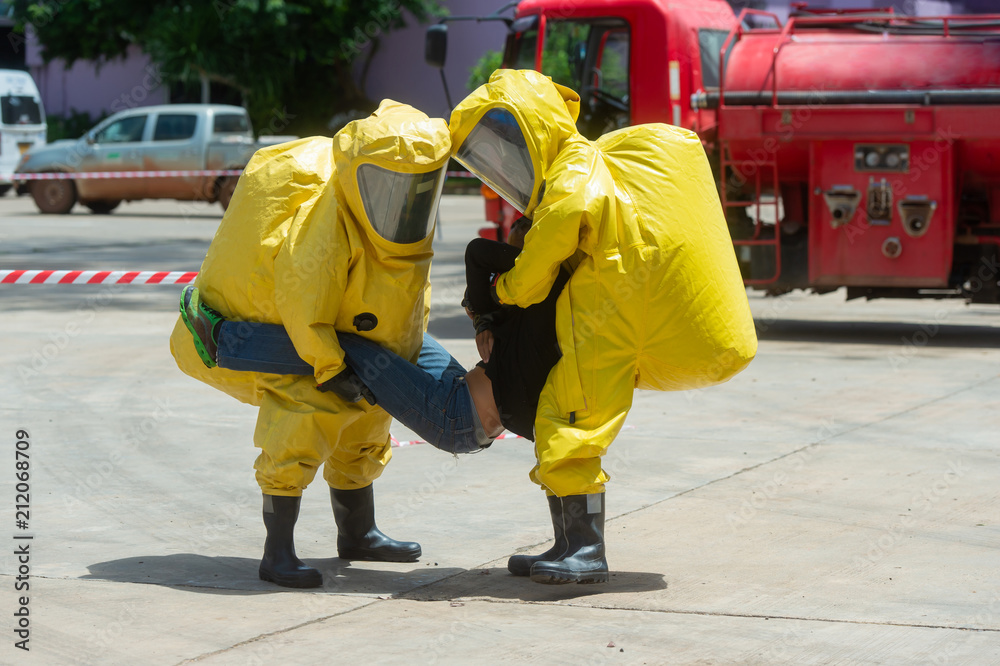 Fireman wear hazmat (hazardous material) suits carry the rescue victim ...