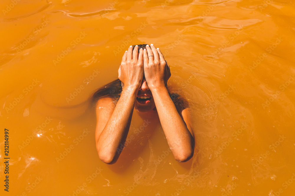 Woman swimming in resort mud pool Stock Photo | Adobe Stock