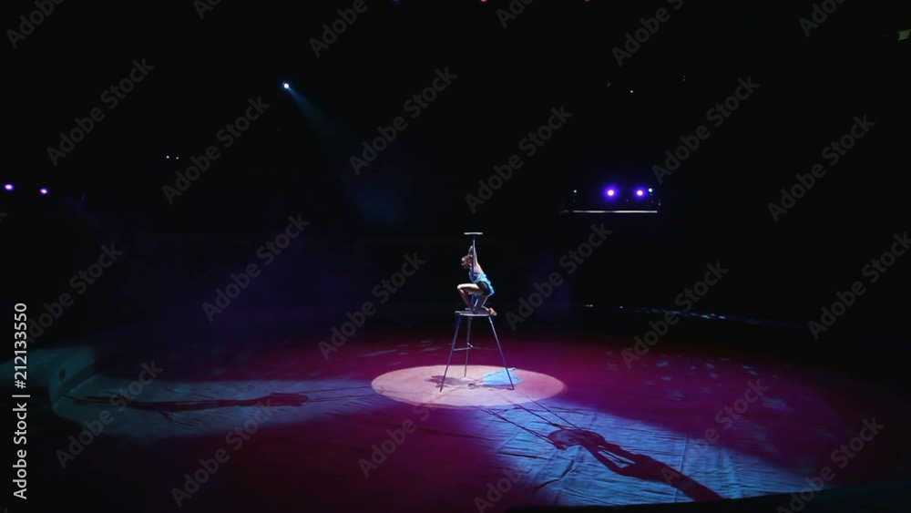 Young flexible acrobat girl executes tricks on a cube in circus Stock ...