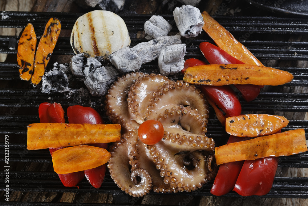 Grilled octopus served with carrot, pepper and onion. Octopus is a ...
