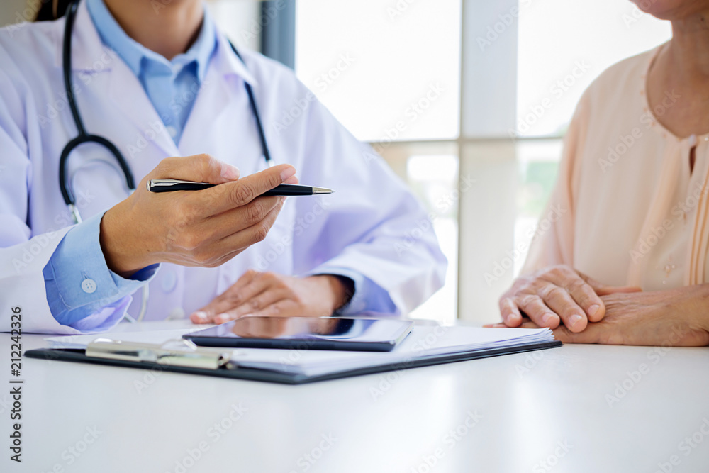 Patient listening intently to a male doctor explaining patient symptoms ...