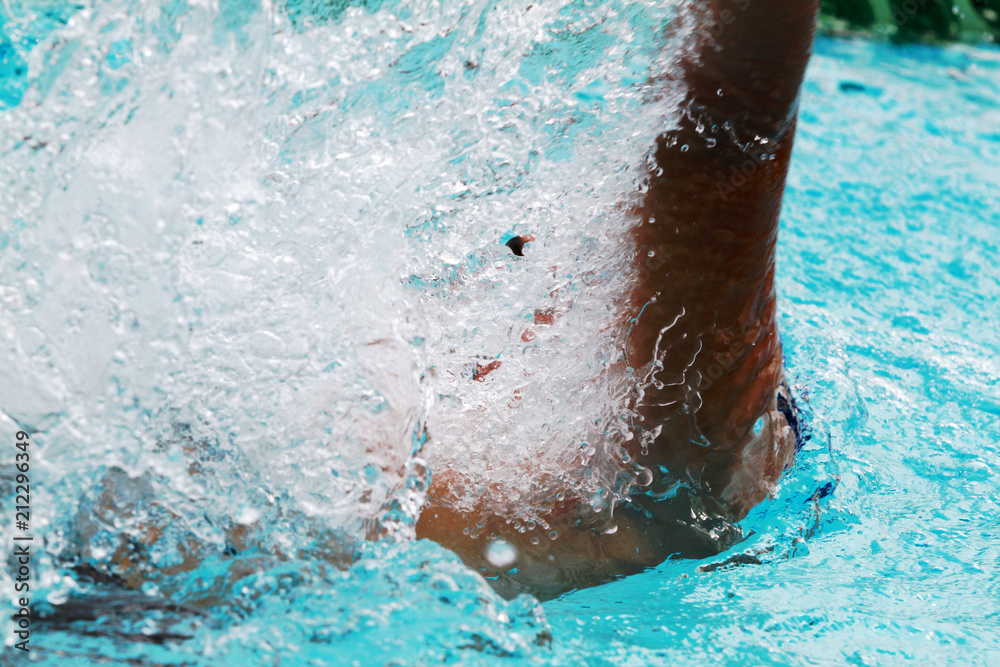 Abstract water splash from young swimmer swims in the swimming pool ...