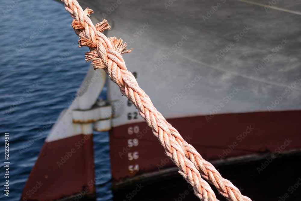 Ship mooring rope on the port wharf. Harbor bollard for large naval ...