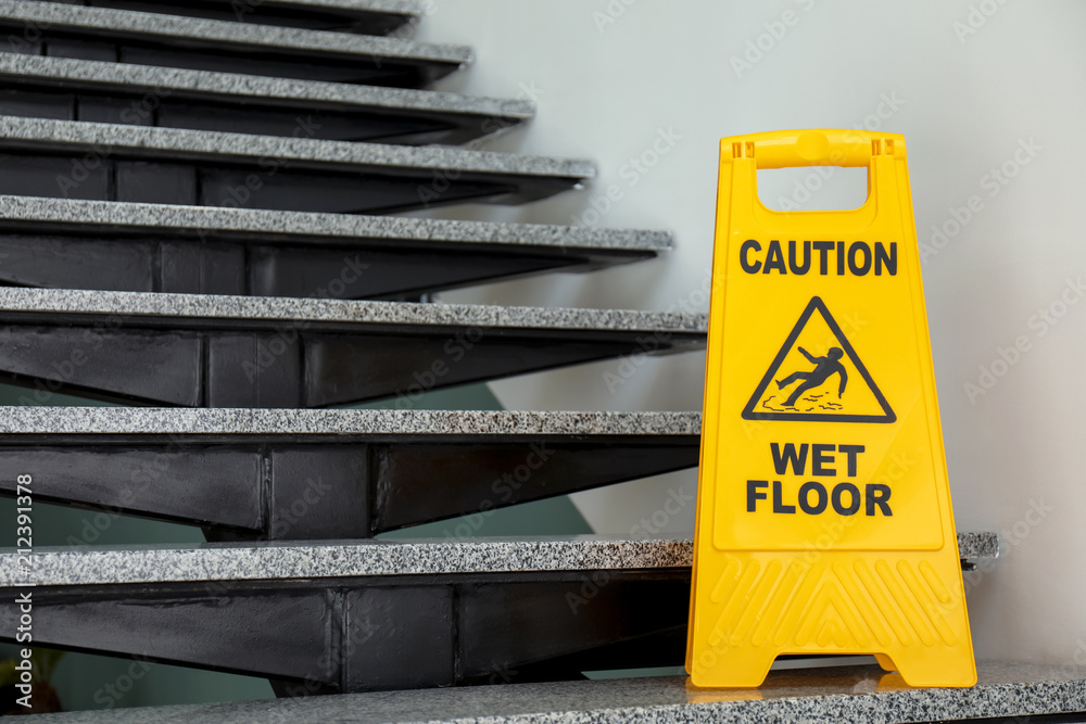Safety sign with phrase Caution wet floor on stairs. Cleaning service ...