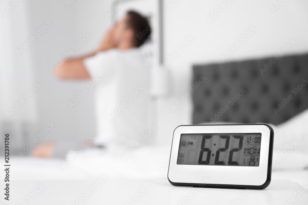 Digital alarm clock and blurred man on background. Time of day Stock ...