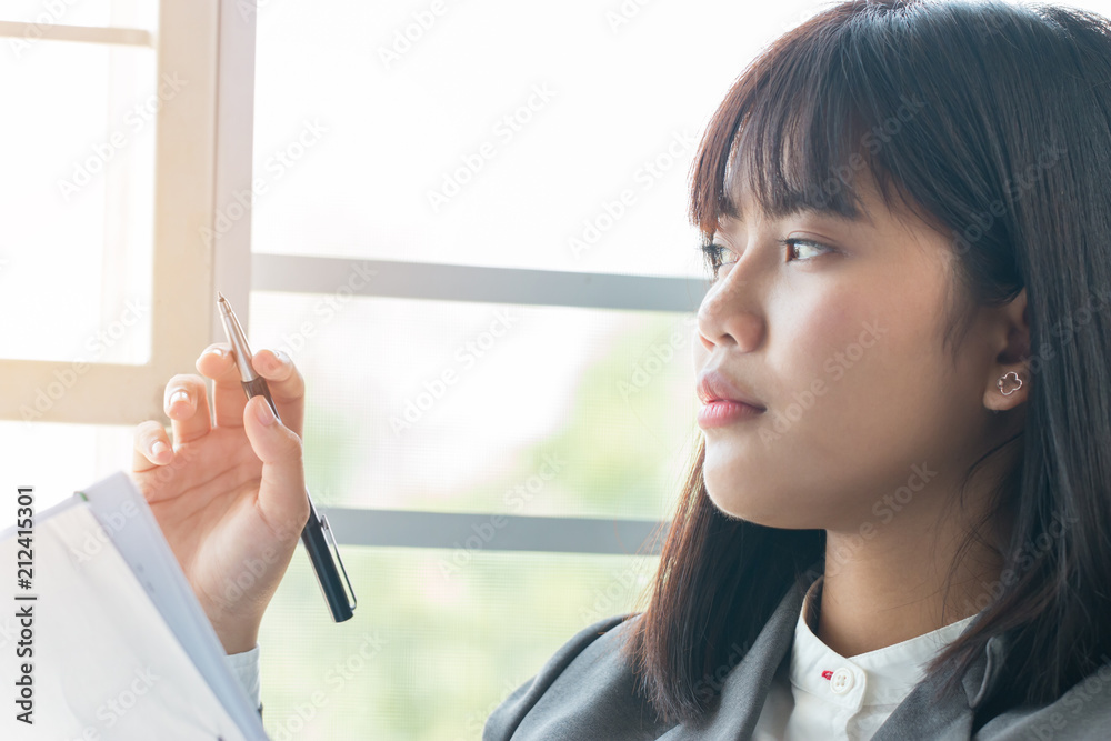 Portrait of Asian female student thinking over working homework and ...