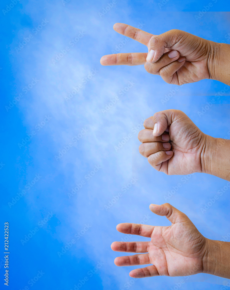 Rock Paper and Scissors on sky background. Hand young man are playing ...
