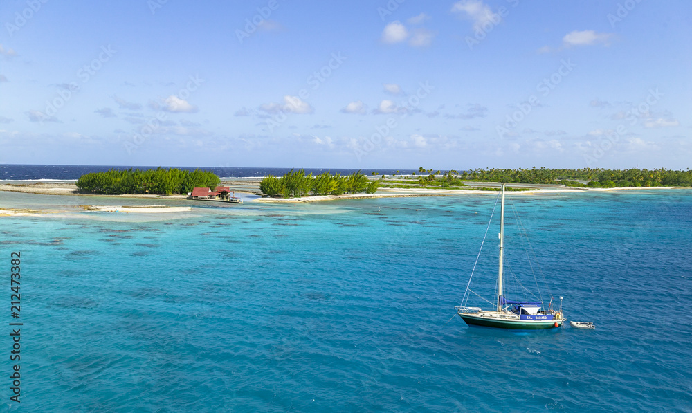 sailing yacht anchoring in the shallow, turquoise lagoon of Fakarava ...