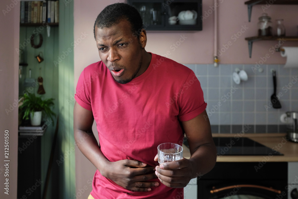 Foto de Indoor picture of miserable African man staying at home ...