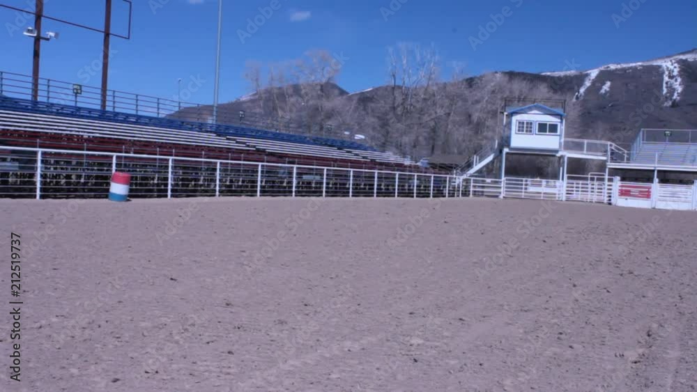 An empty rodeo arena, pan from left to right across the bucking shoots ...