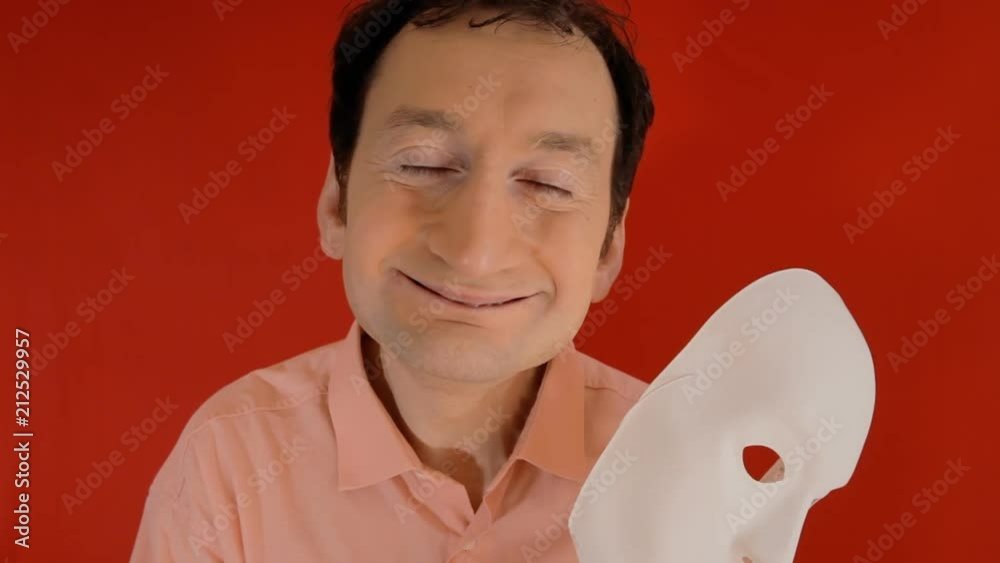 A man hiding behind a cheap plastic mask, removing it and revealing a ...