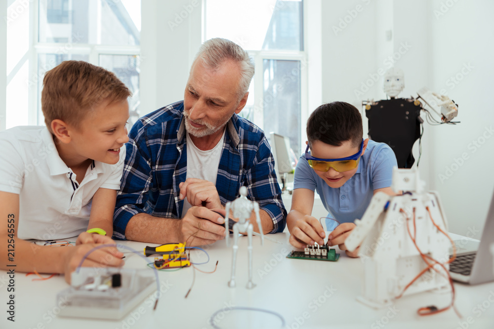 Practical knowledge. Positive joyful children sitting around their ...