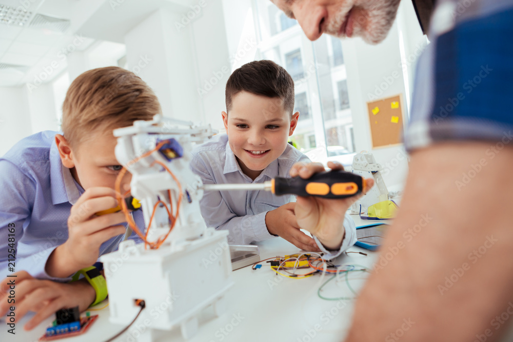 Science technology. Positive cute boy holding a screwdriver while ...
