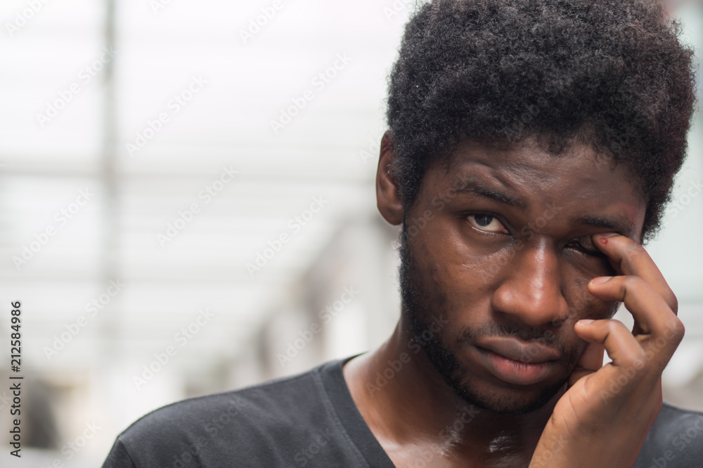 man suffering from irritated eye; sick african man with eye pain, sore ...