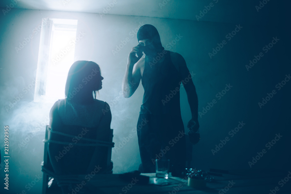 Kidnapper and his victim are in dark room with small window. He is ...