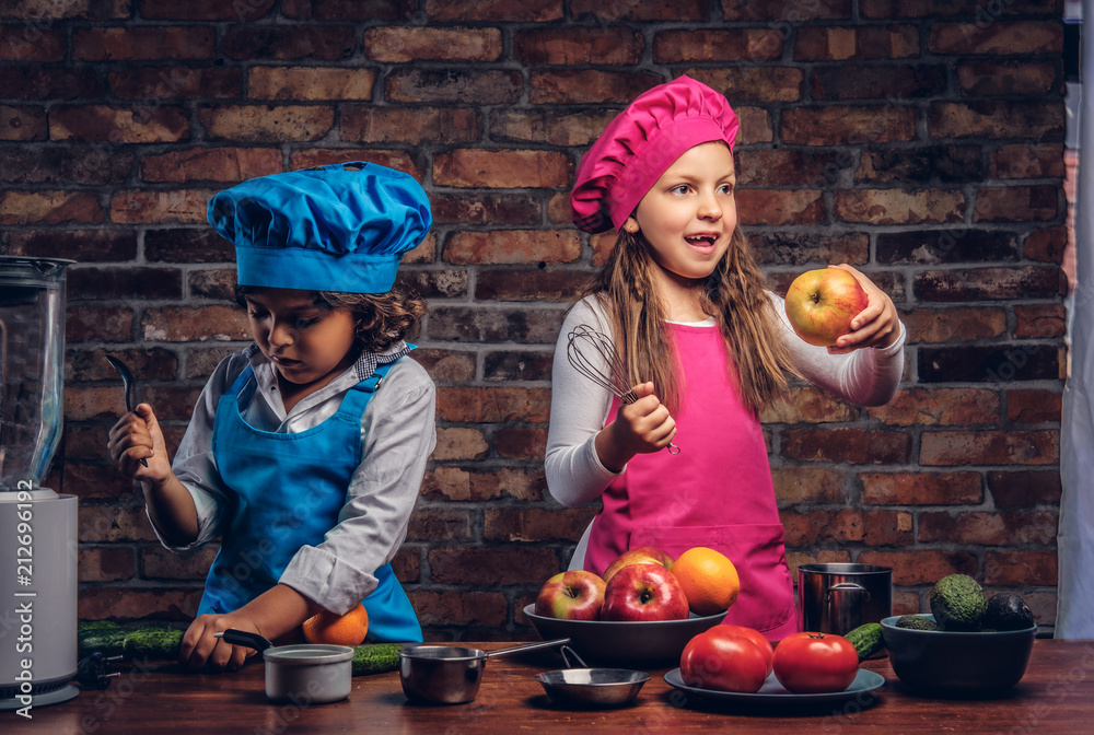 Cute cook couple. Little boy with brown curly hair dressed in a blue ...
