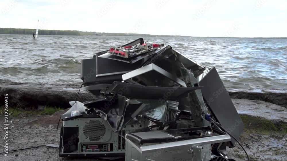 Broken computer parts, monitors and printers in front of nature ...