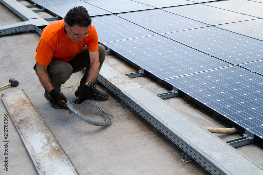 fitting photovoltaic panels on a roof Stock Photo | Adobe Stock