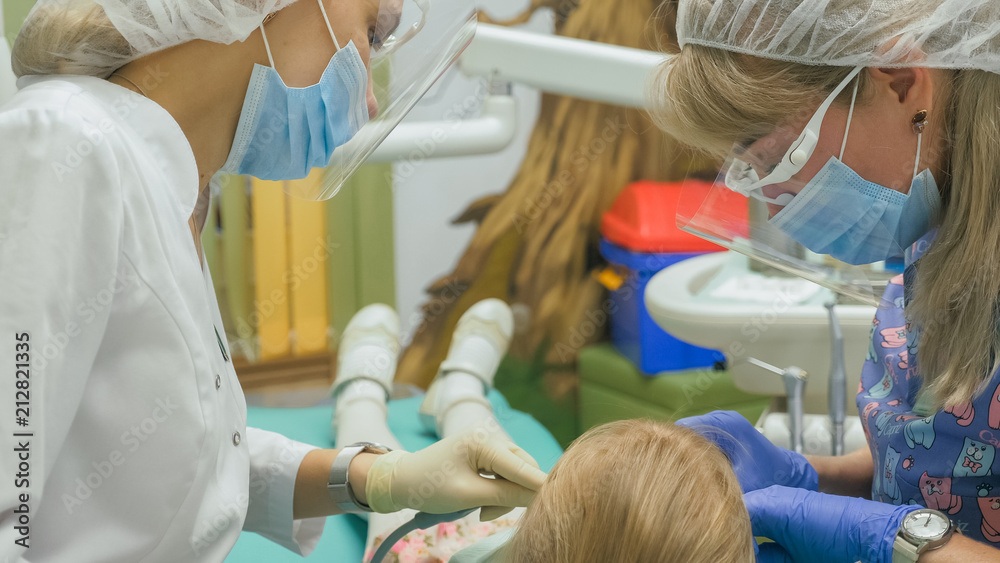 Child with a mother at a dentist's reception. The girl lies in the ...