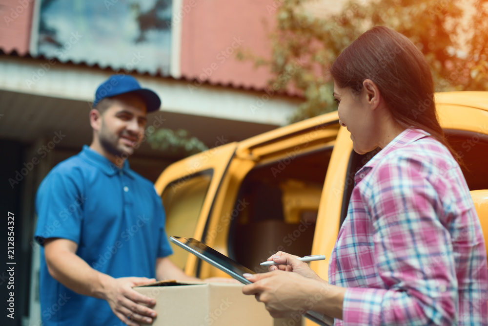 Cheerful delivery boy giving client their order. Friendly delivery man ...