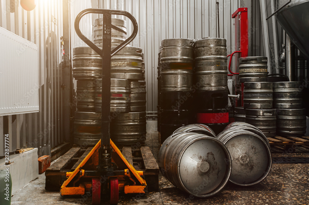 Many metal beer keg stand in a warehouse of brewery. Time to delivery ...