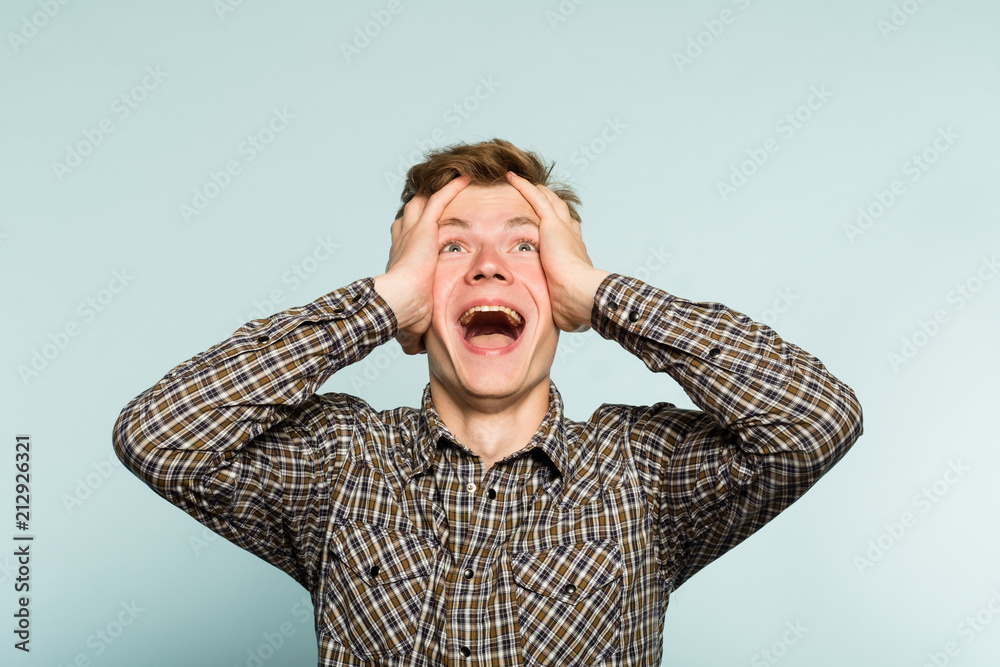overjoyed extremely happy and excited man clutching his head. portrait ...