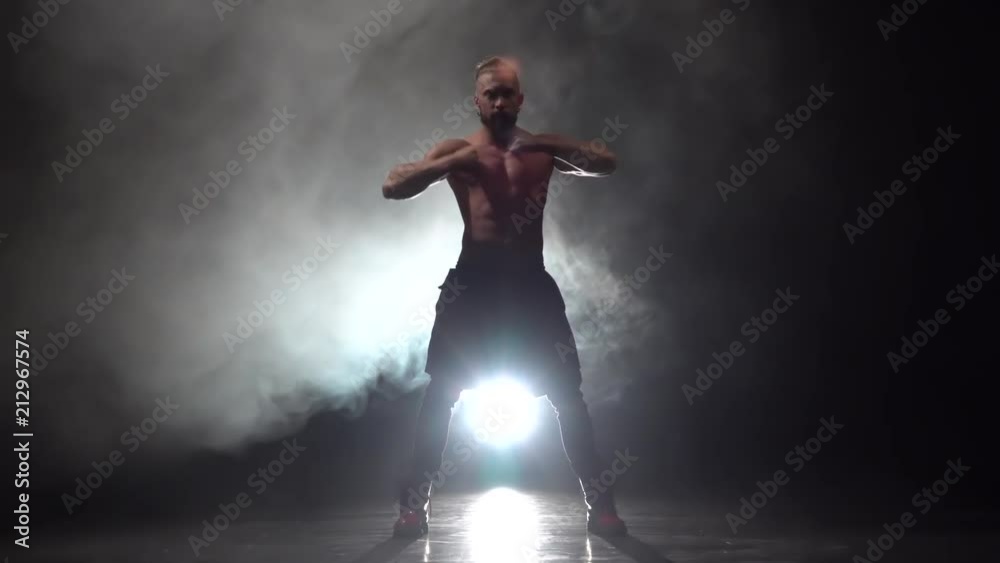 Bearded man is dancing a strip with a bare . Smoke background. Slow ...