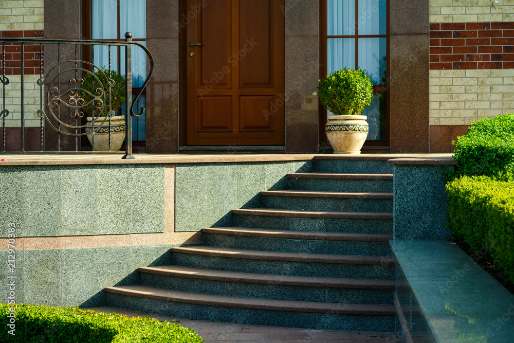 Entrance group in a modern stone house with marble steps into the house ...