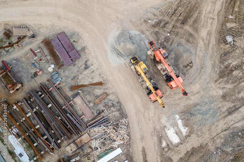 Aerial top view: constraction crane or trucks go together country road ...