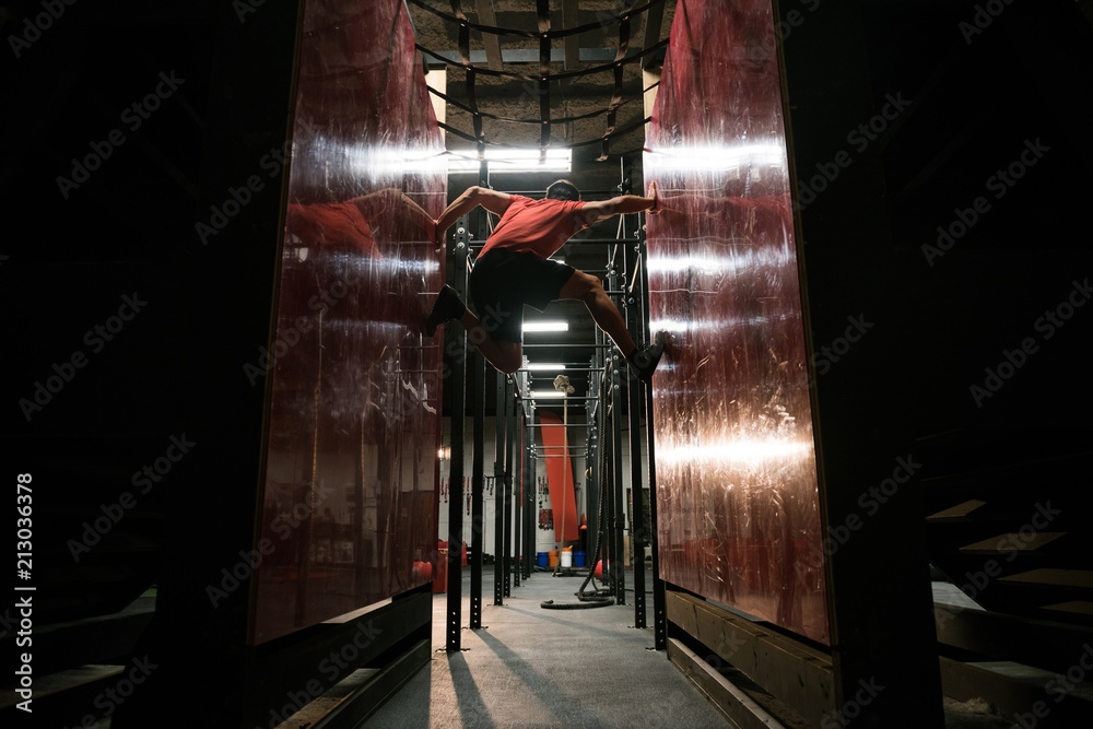 Muscular man climbing between two walls Stock Photo | Adobe Stock