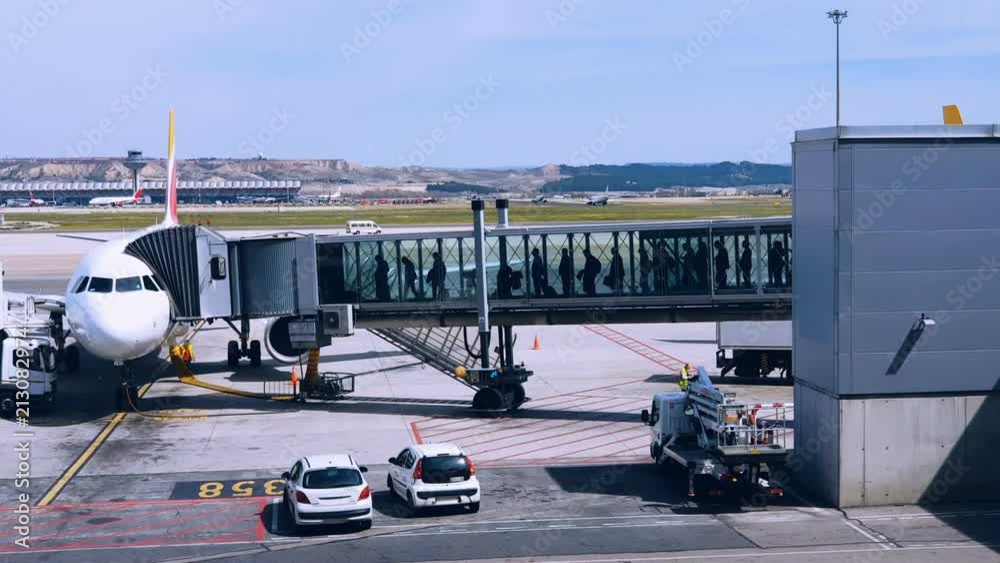 Airport passengers boarding on a plane, people walking through jet ...