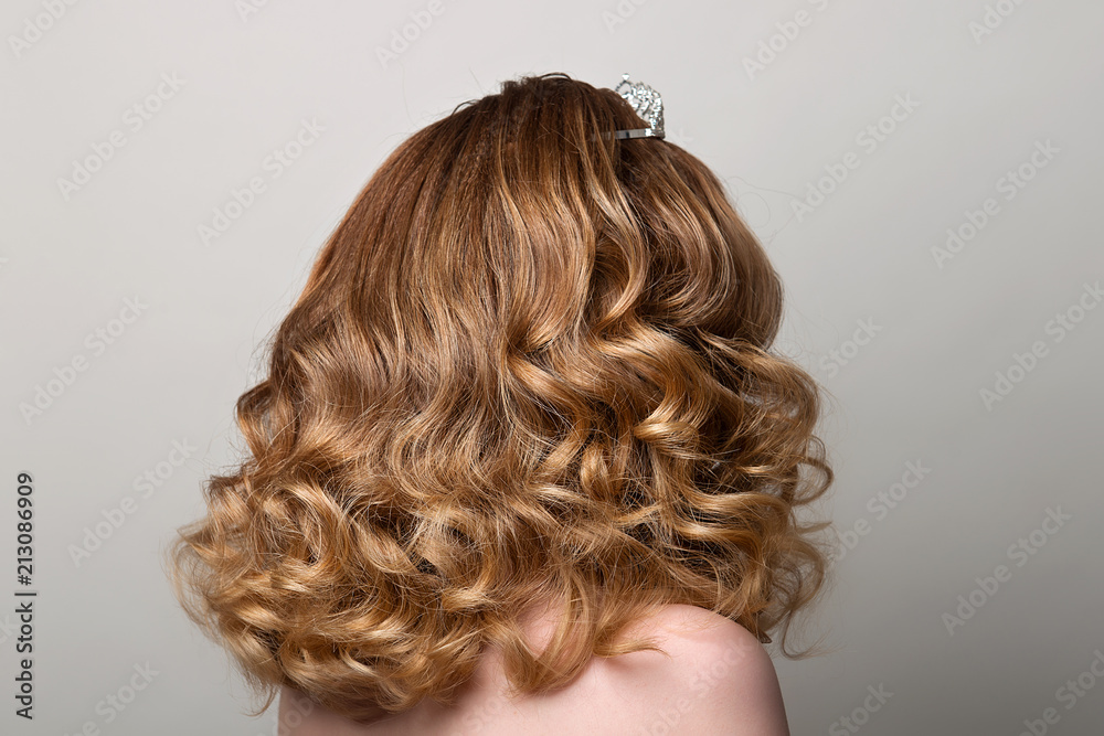 Female hairstyle long curls on the head of the brown-haired woman ...