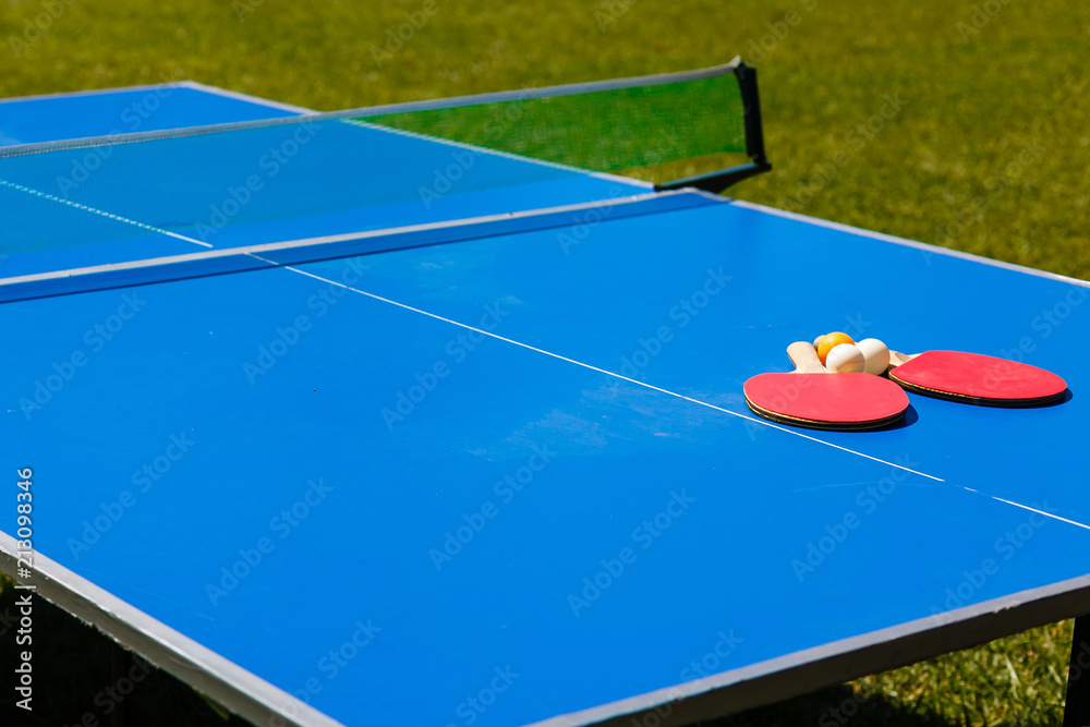 Rackets for table tennis of red color and a ball on a tennis table ...