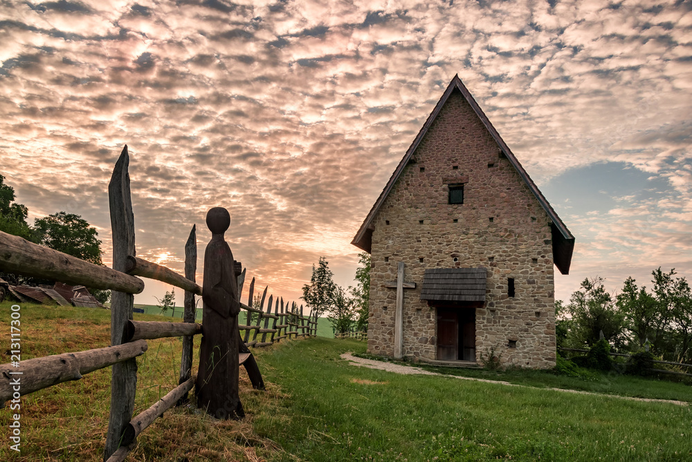 Replica of an early meddieval church in a rural area during a sunrise ...